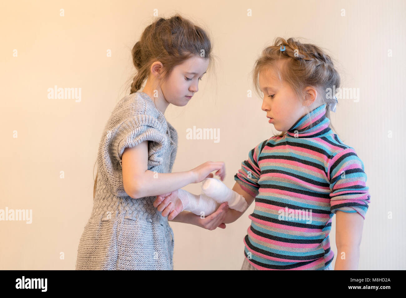 Two, girls, play, doctor. Bandage your arm with a bandage. Hand injury ...