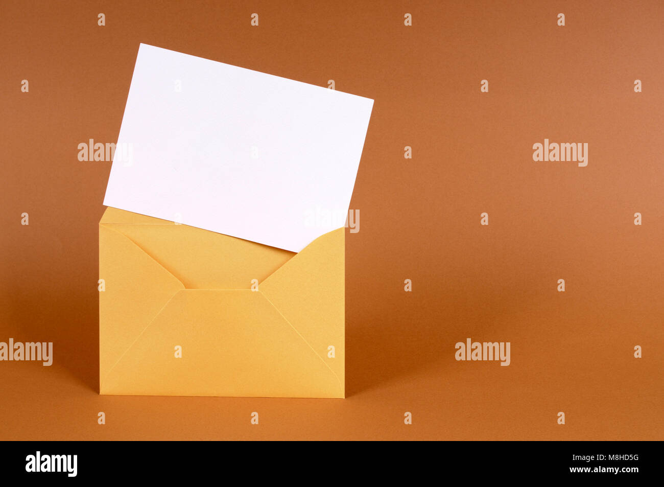 Gold envelope with blank message card letter or invitation isolated on ...