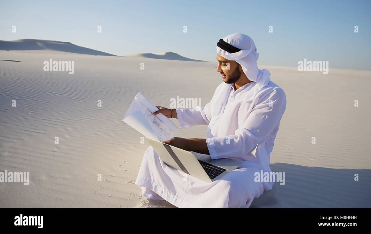 Muslim Arabian UAE Sheikh architect sitting with laptop on sand Stock ...