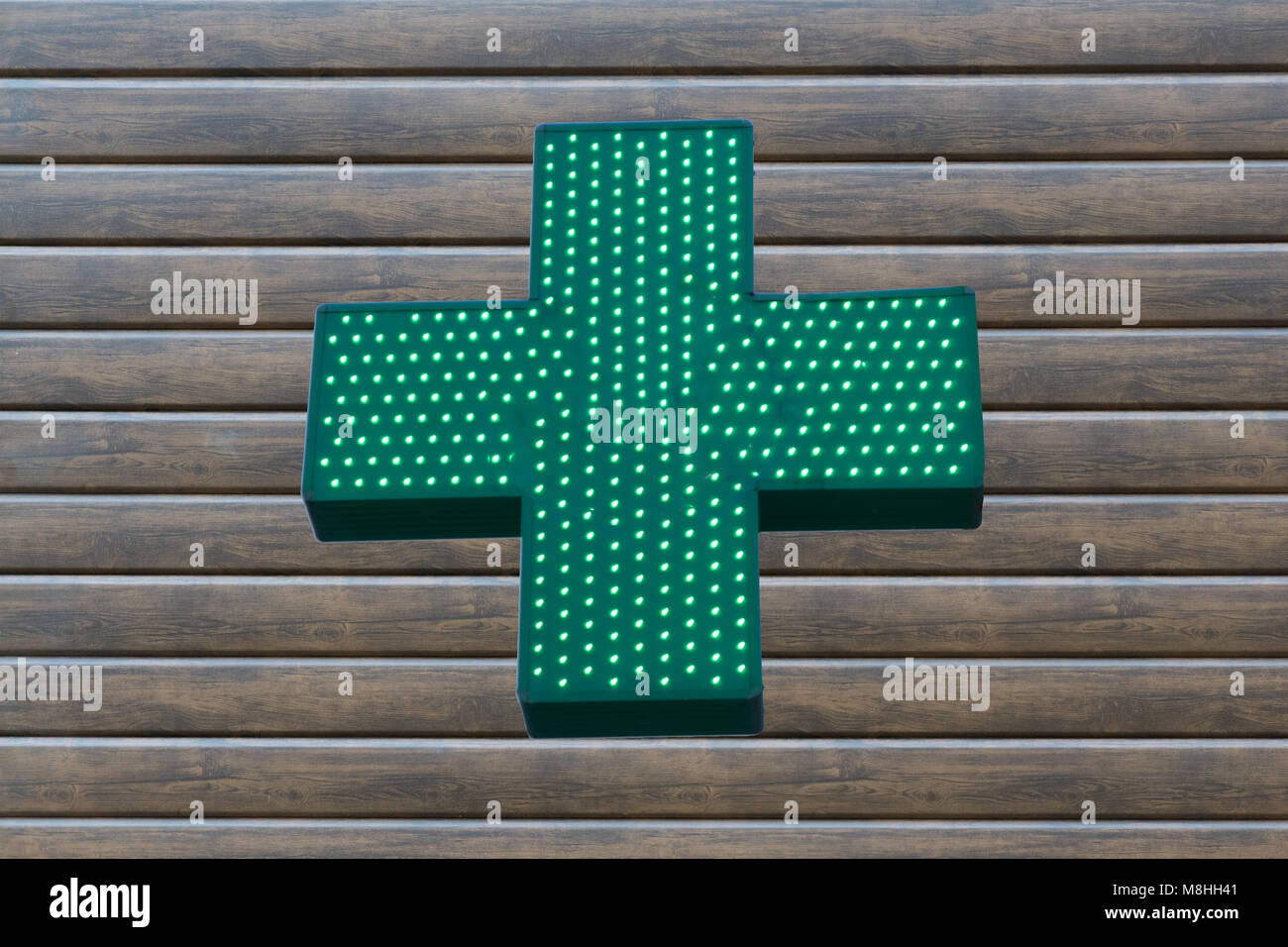 Neon green cross sign on wooden background Stock Photo - Alamy