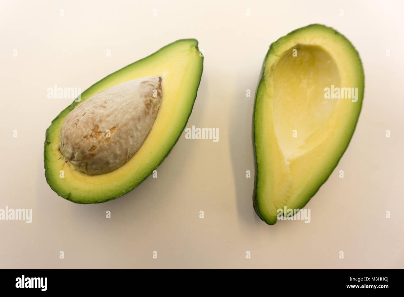Two slices of avocado isolated on the white background. One slice with ...