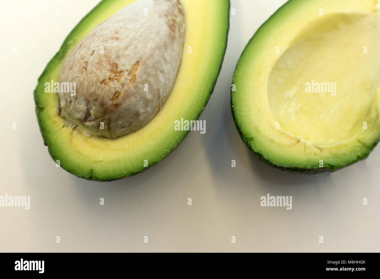 whole and half avocado isolated on white background close-up. Top view ...
