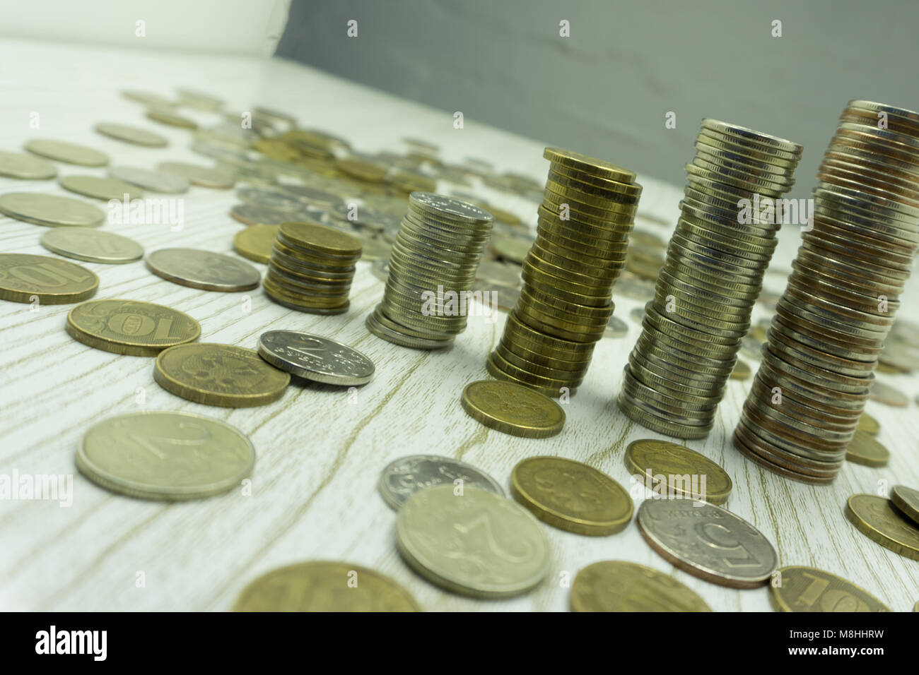 Five stacks of coins with growth between stacking limits on white ...