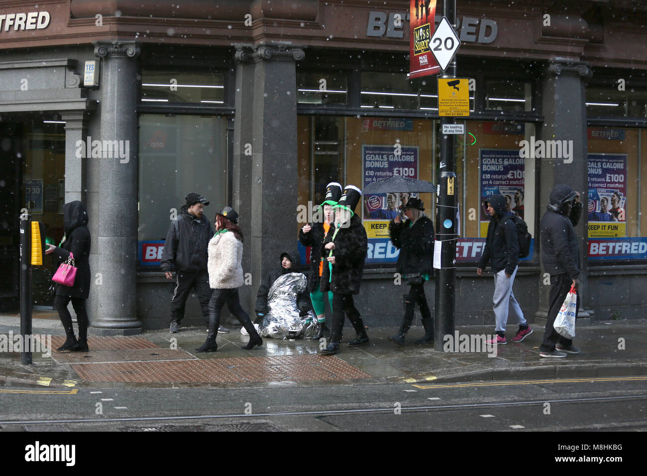 Manchester, UK, 17 Mar 2018. A homeless man wrapped in foils sits on ...