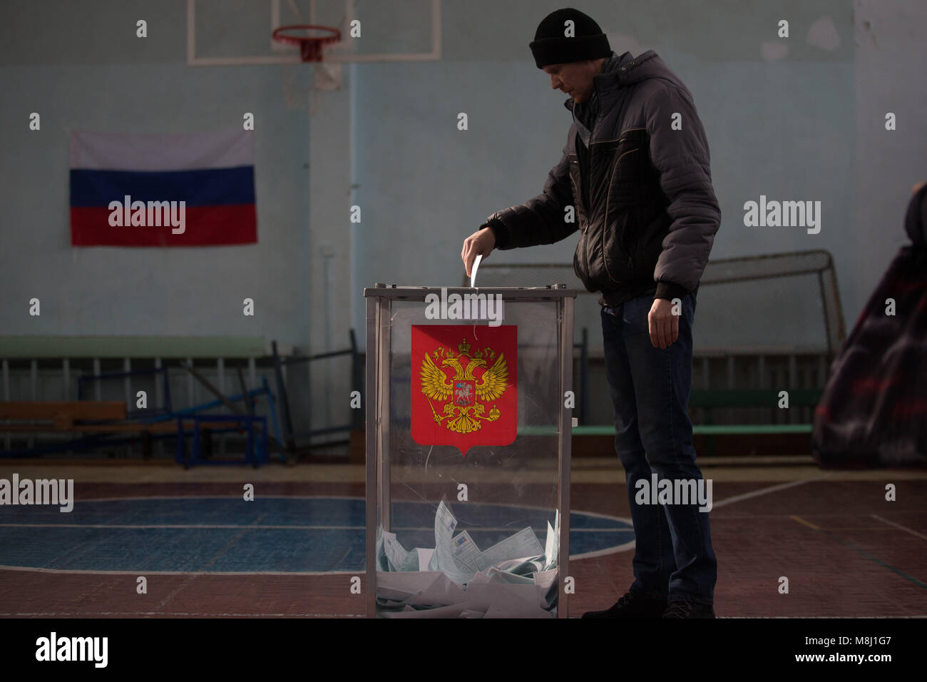 Saint Petersburg, Russia. 18th Mar, 2018. A man casts his ballot paper ...