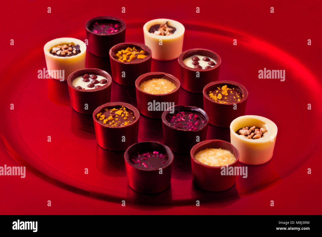 Assortment of luxury white and dark chocolate candies variety on red ...