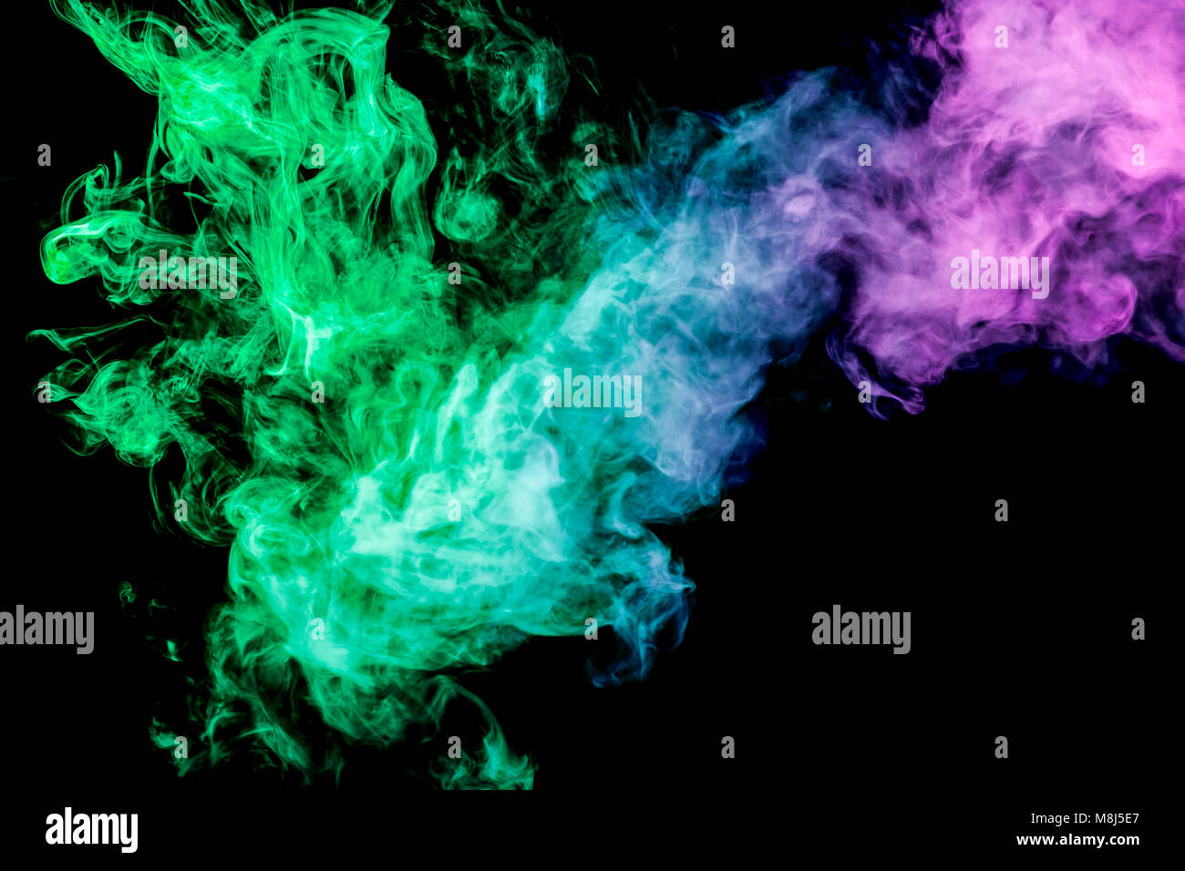 Thick pink, green and blue colorful smoke of on a black isolated ...