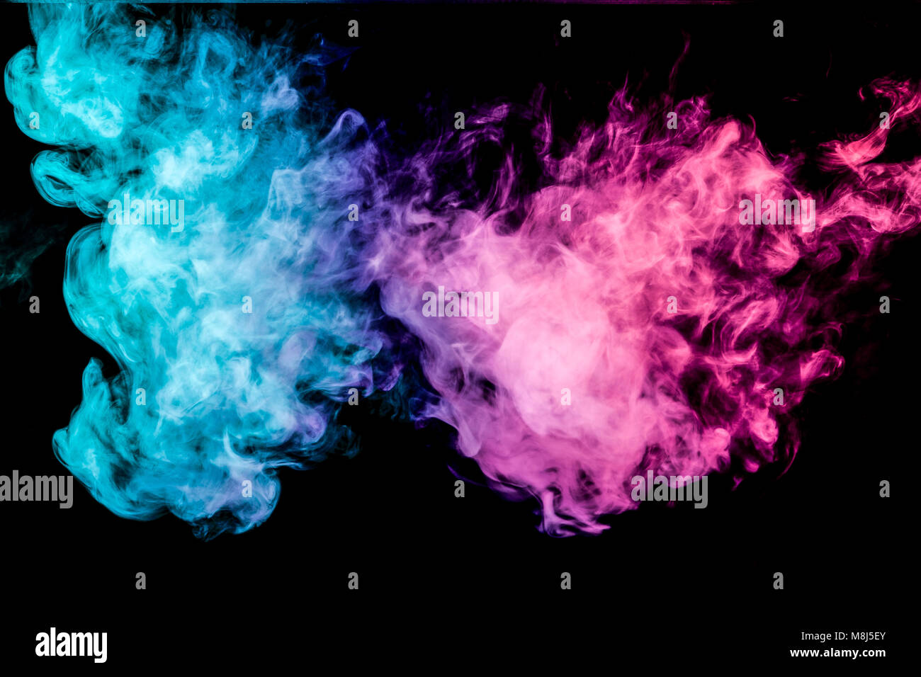 Colorful smoke of pink and blue on a black isolated background ...