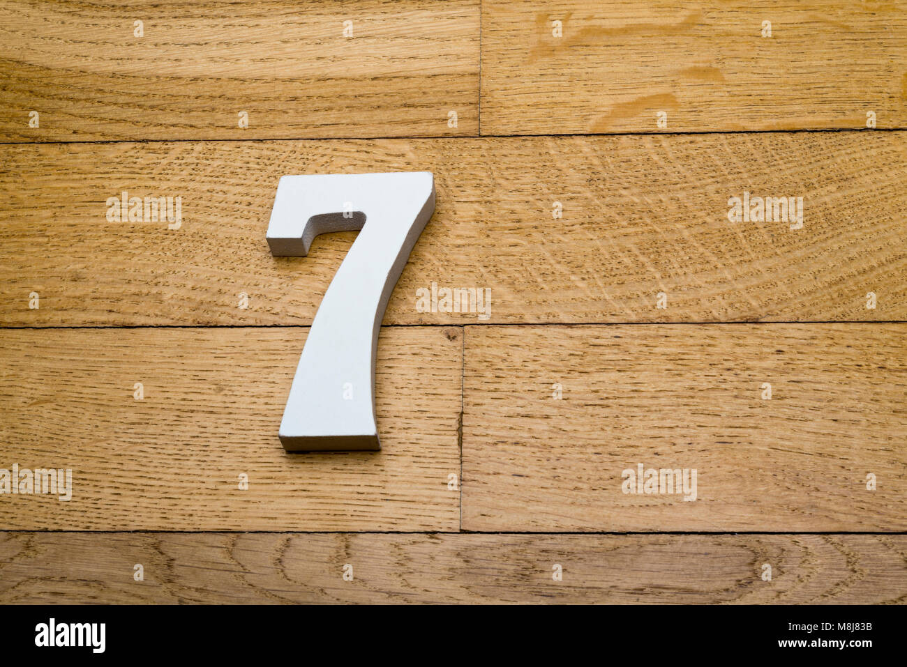 The figures are seven on a wooden, parquet floor as a background Stock ...