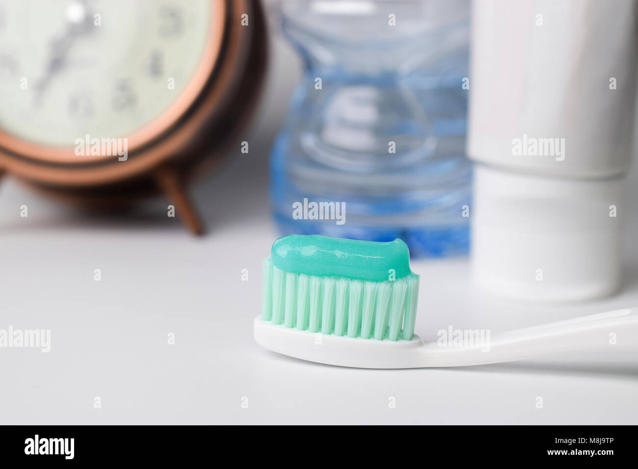 Green toothpaste on a toothbrush on white background - closeup Stock ...