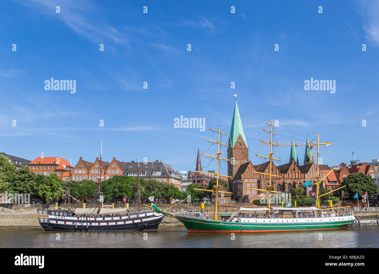 Historical ships and church along the river Weser in Bremen, Germany ...
