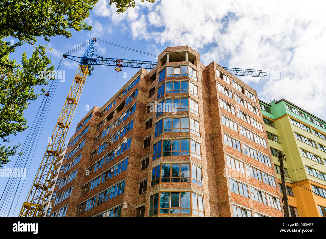 Modern high storey building under construction with tower crane and ...