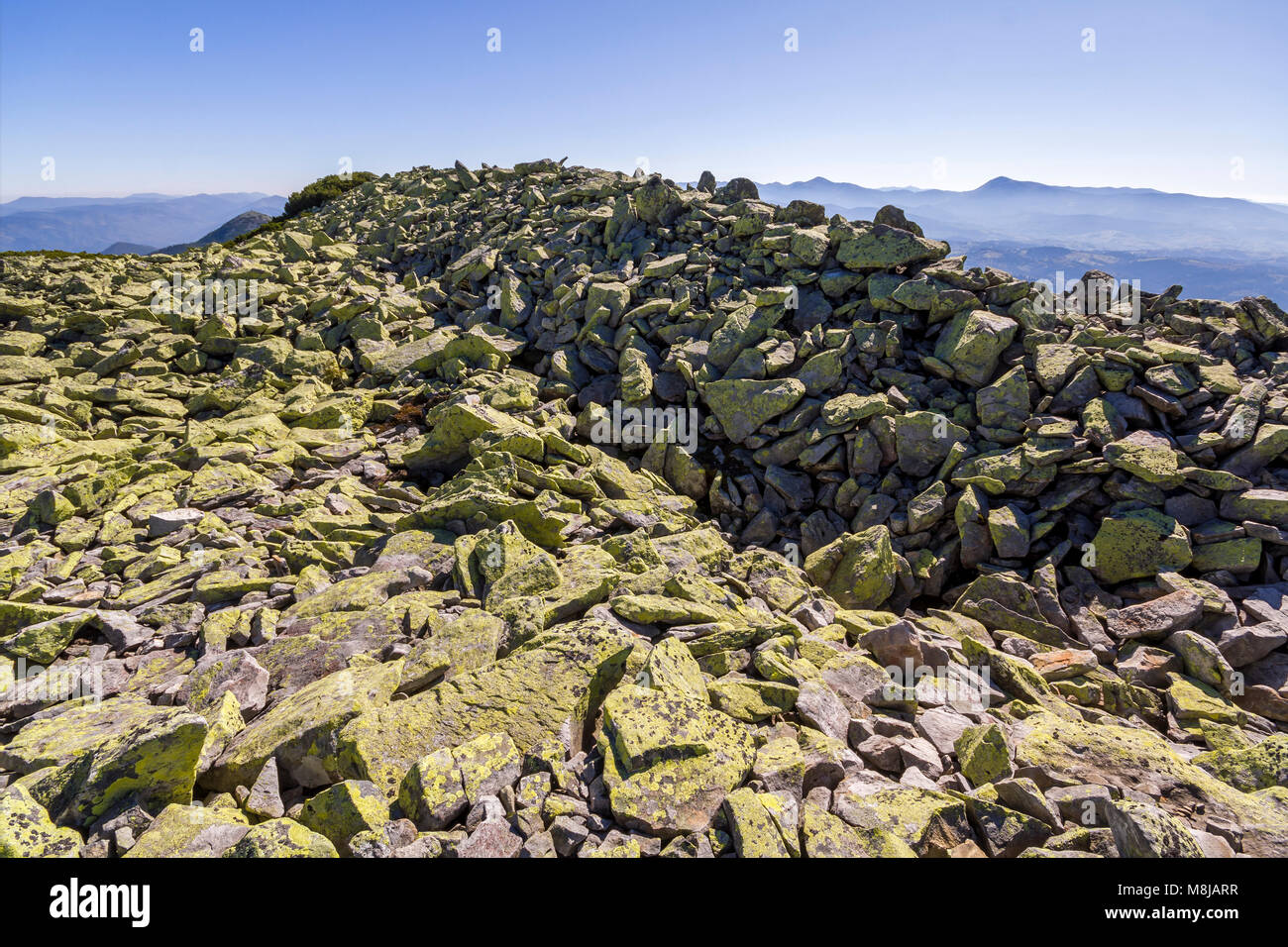 Stack of stones covered with moss on top of a mountain on mountains ...