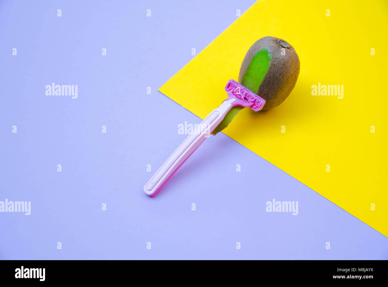 Kiwi fruit and razor on violet and yellow background. Hair removal ...