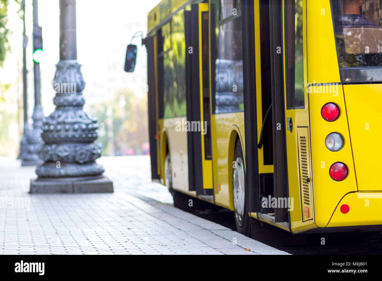 Modern yellow city bus with open doors at bus station Stock Photo - Alamy