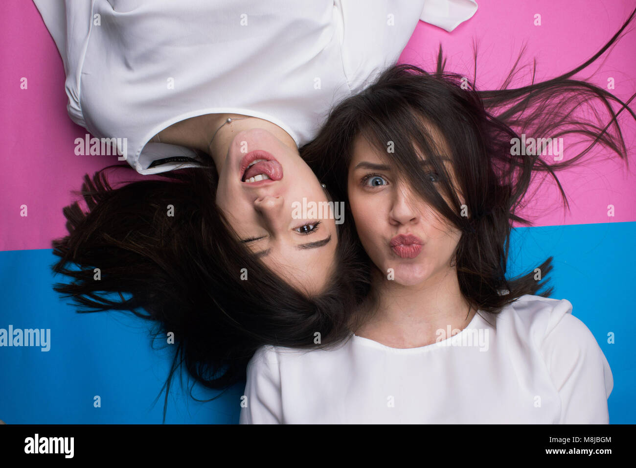 two young beautiful girls have a fun isolated Stock Photo - Alamy