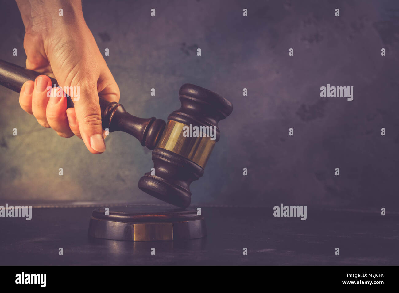 Someones hand holding law gavel - law and justice concept, retro toned ...