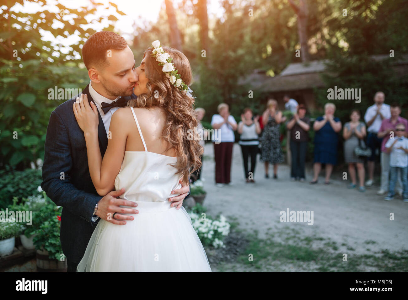 the groom kisses the bride in front of the guests at the exit ceremony ...