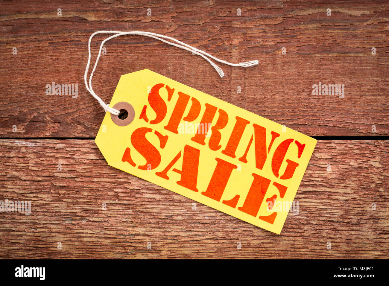 spring sale sign - red stencil text on a yellow paper price tag against ...
