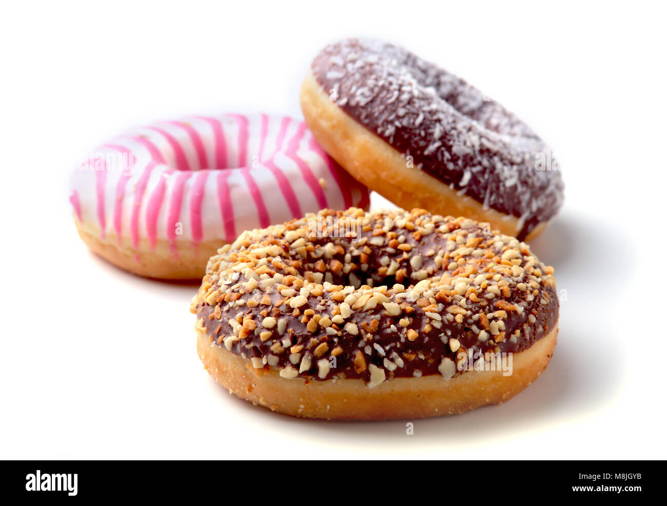 Assorted doughnuts in the glaze, colorful sprinkles and nuts on a white ...