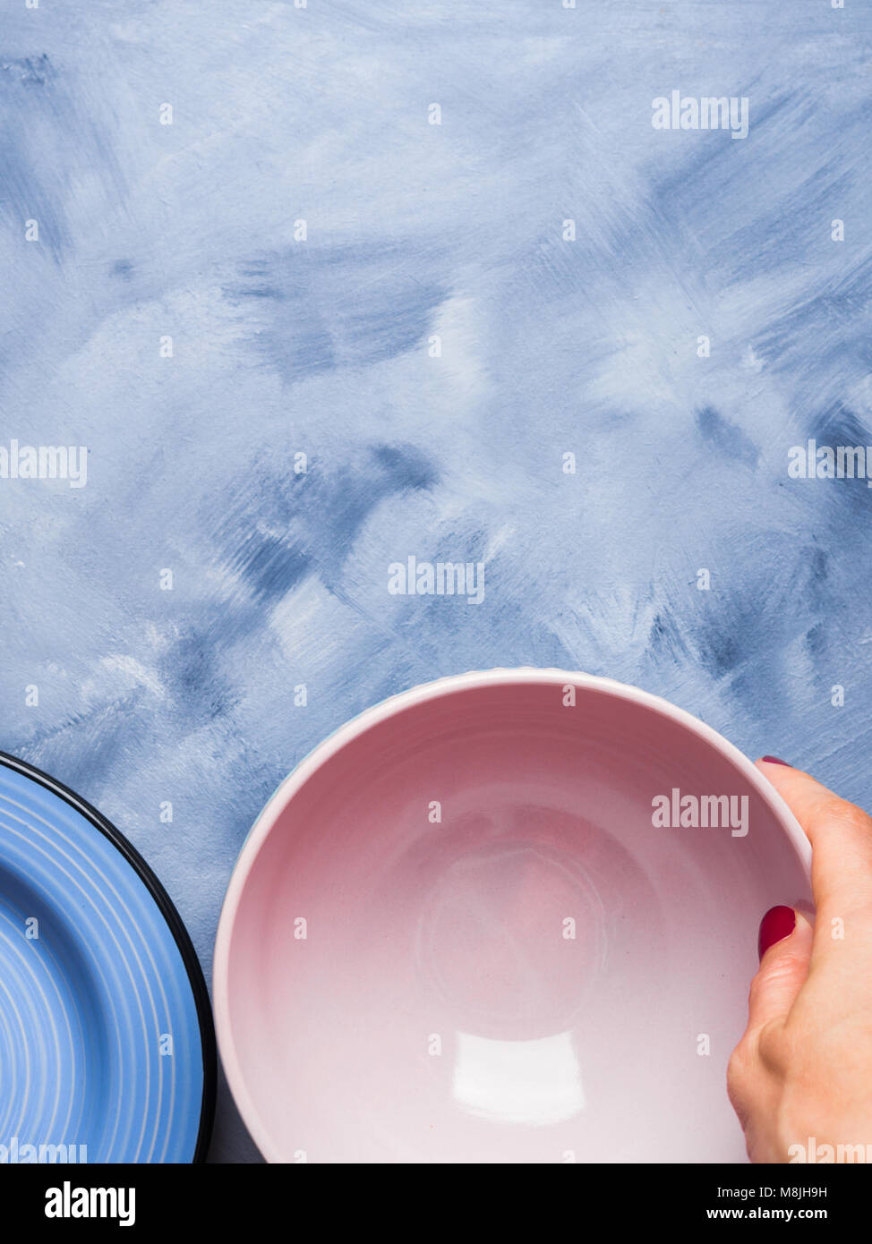 Pastel color plate and bowl with woman's hand holding it Stock Photo ...