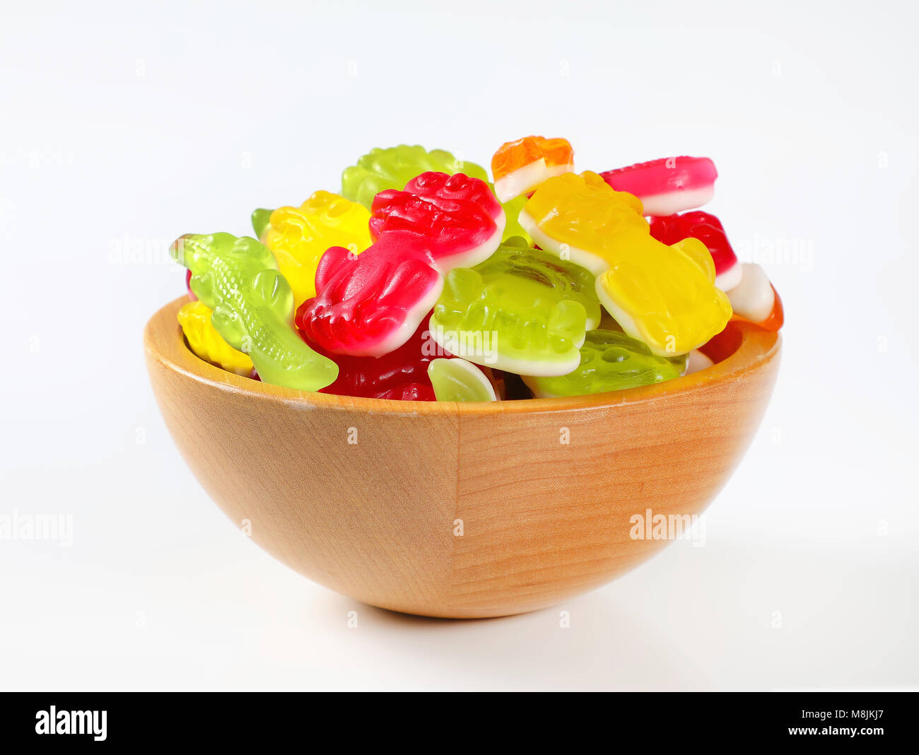 bowl of colorful gummy candies in the shape of animals on white ...