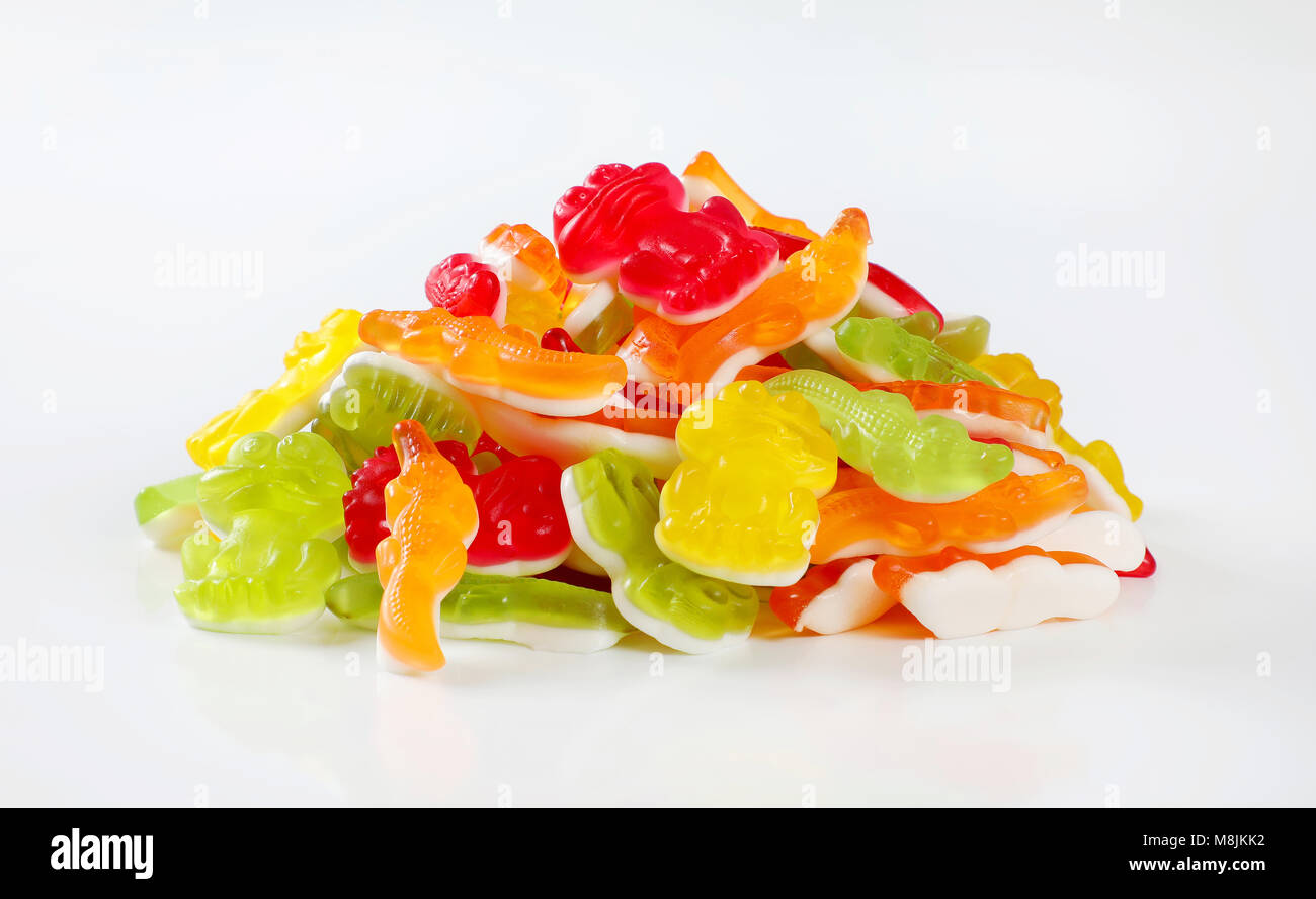 pile of colorful gummy candies in the shape of animals on white ...