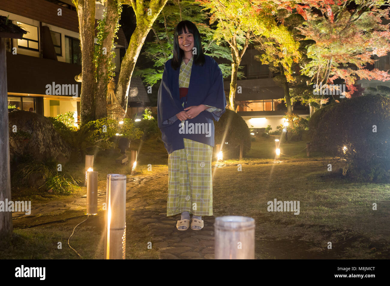 Beautiful young woman in a Yukata strolling through a japanese garden ...