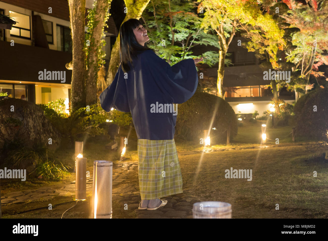 Beautiful young woman in a Yukata strolling through a japanese garden ...