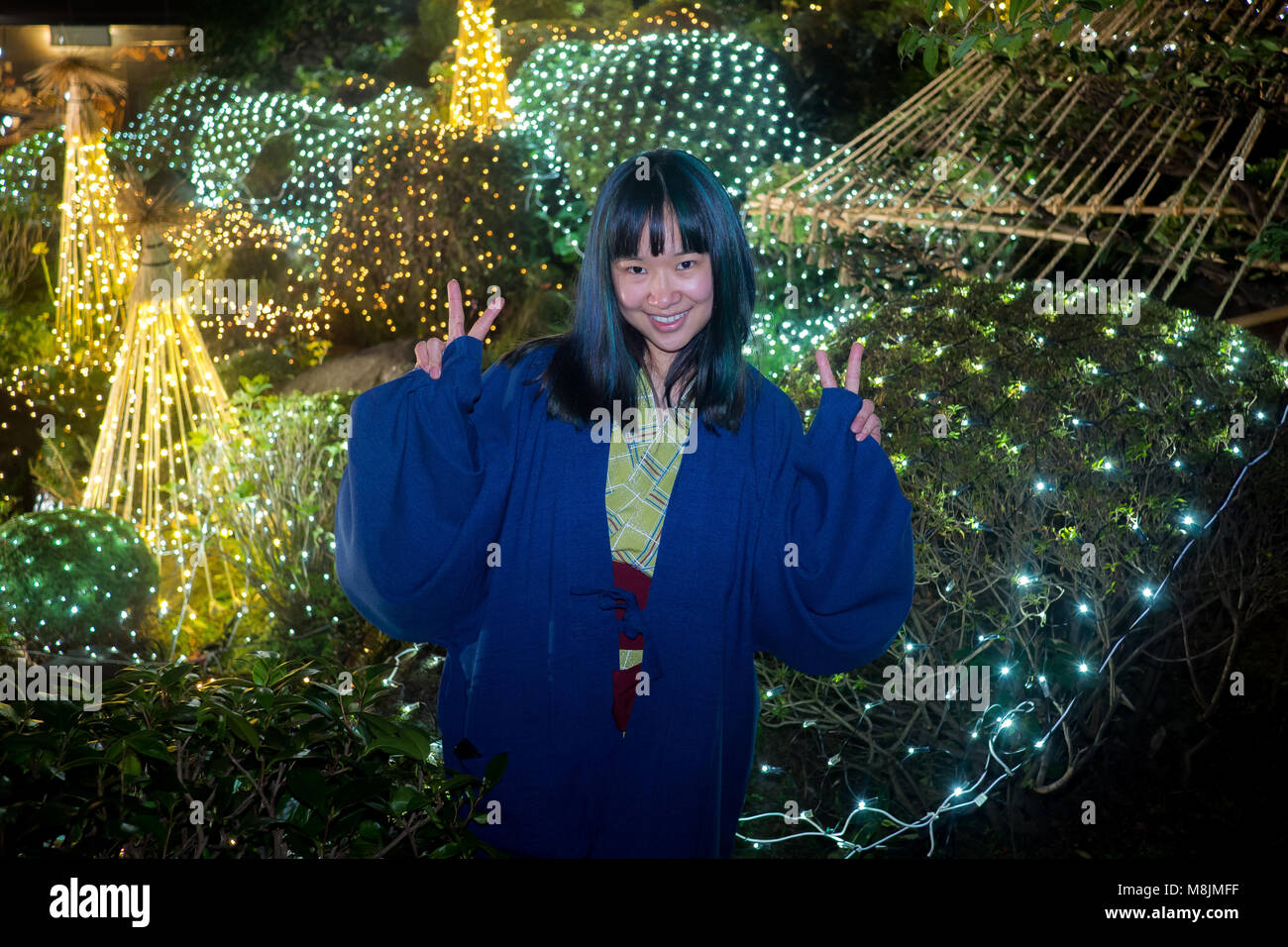 Beautiful young woman in a Yukata posing in a japanese garden that is ...