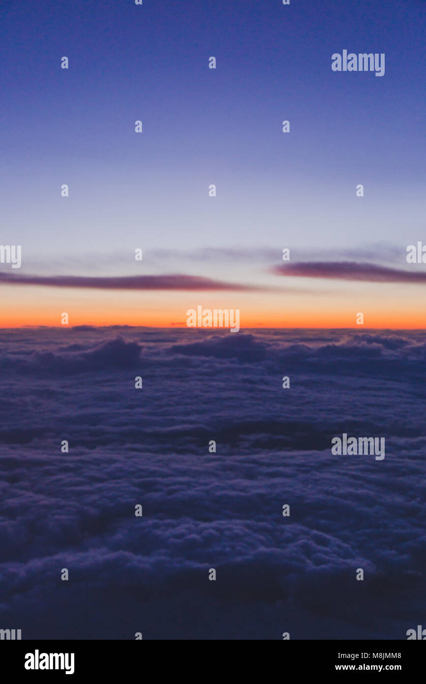 sunset with pink and purple tones shot from airplane window seat of a ...