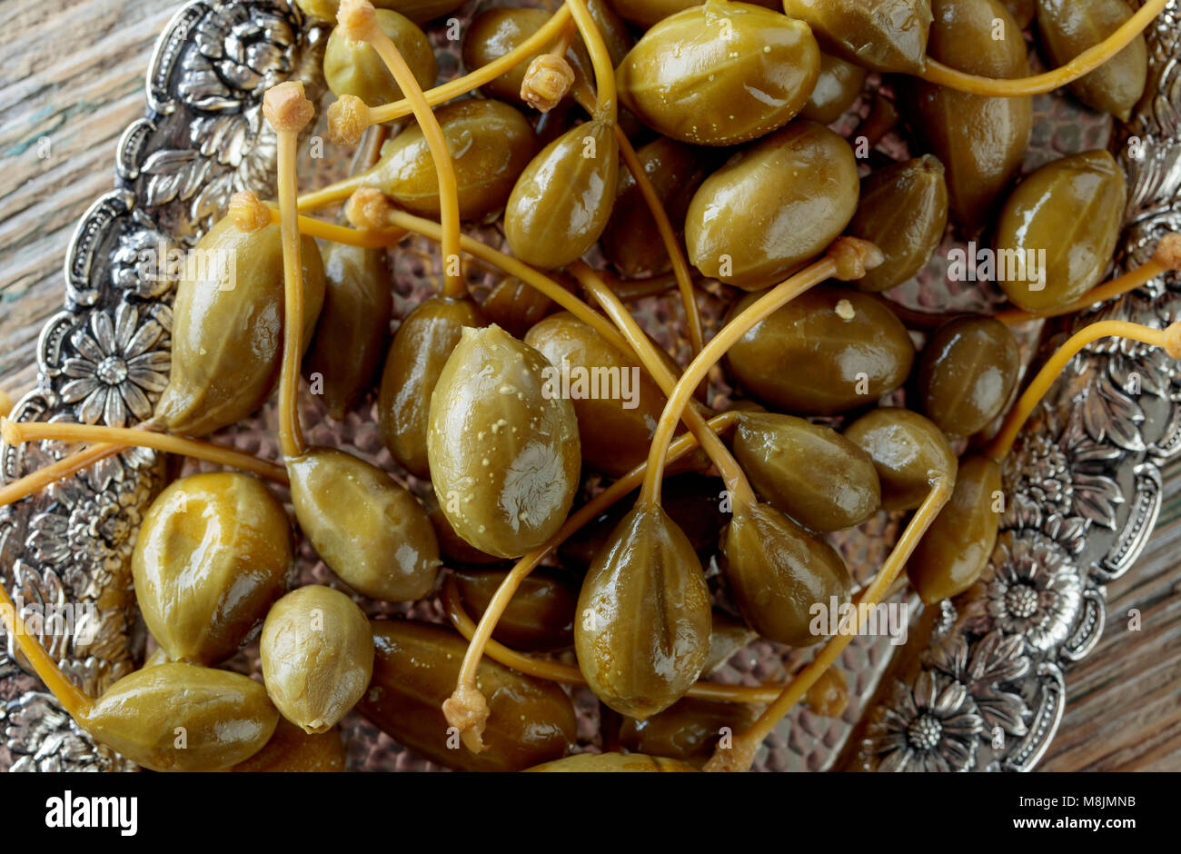 Pickled caper berries in metal dish . Edible fruits of Capparis ...