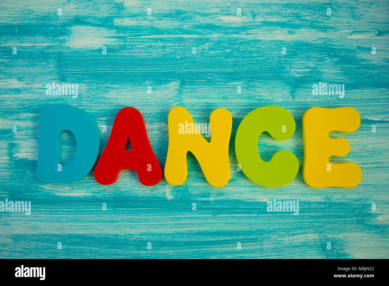 Dance in colourful letters on painted blue wood panel background Stock ...