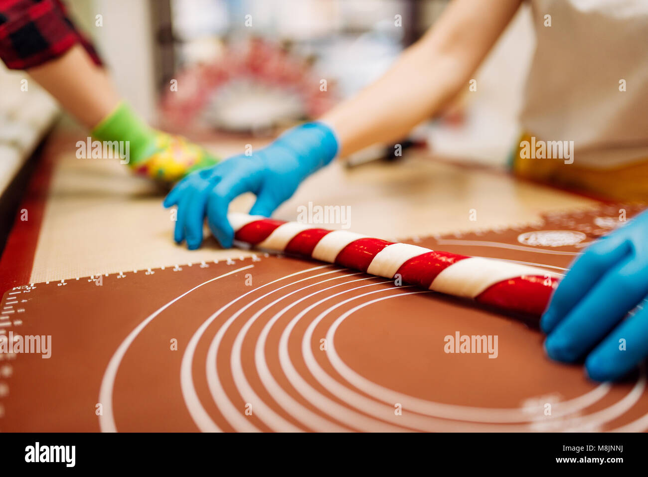 Male chef hands in gloves, caramel making process. Candy preparation in ...