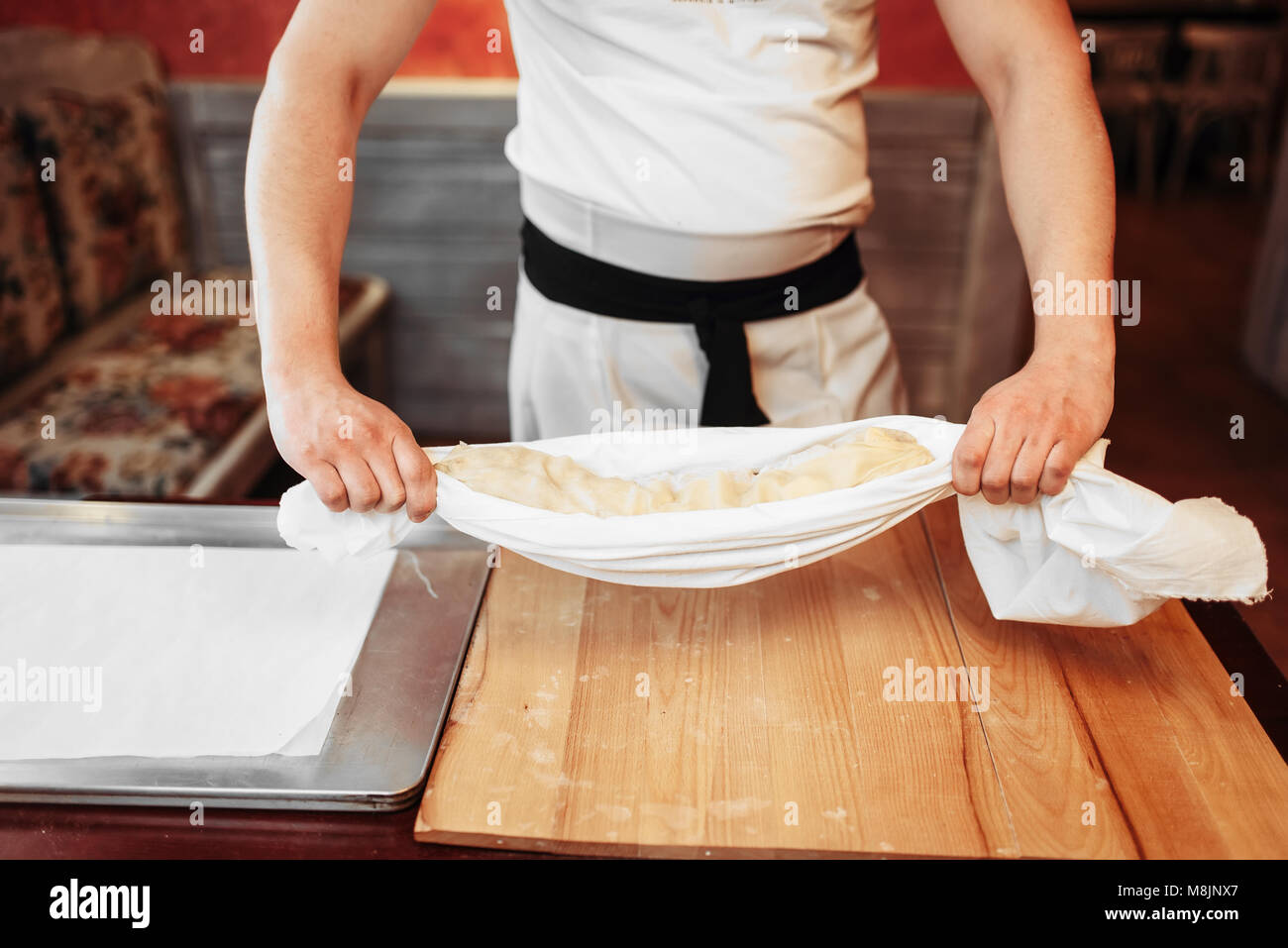 Male chef prepares classical apple strudel, top view, bakery cooking ...