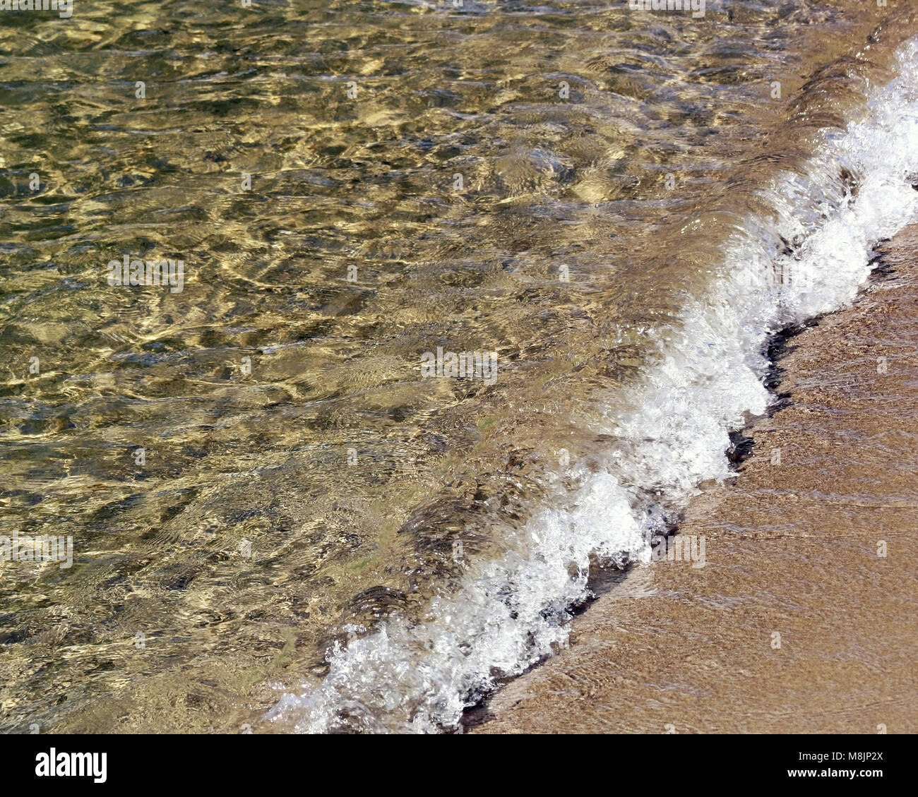 Soft wave rolling onto sandy shore Stock Photo - Alamy