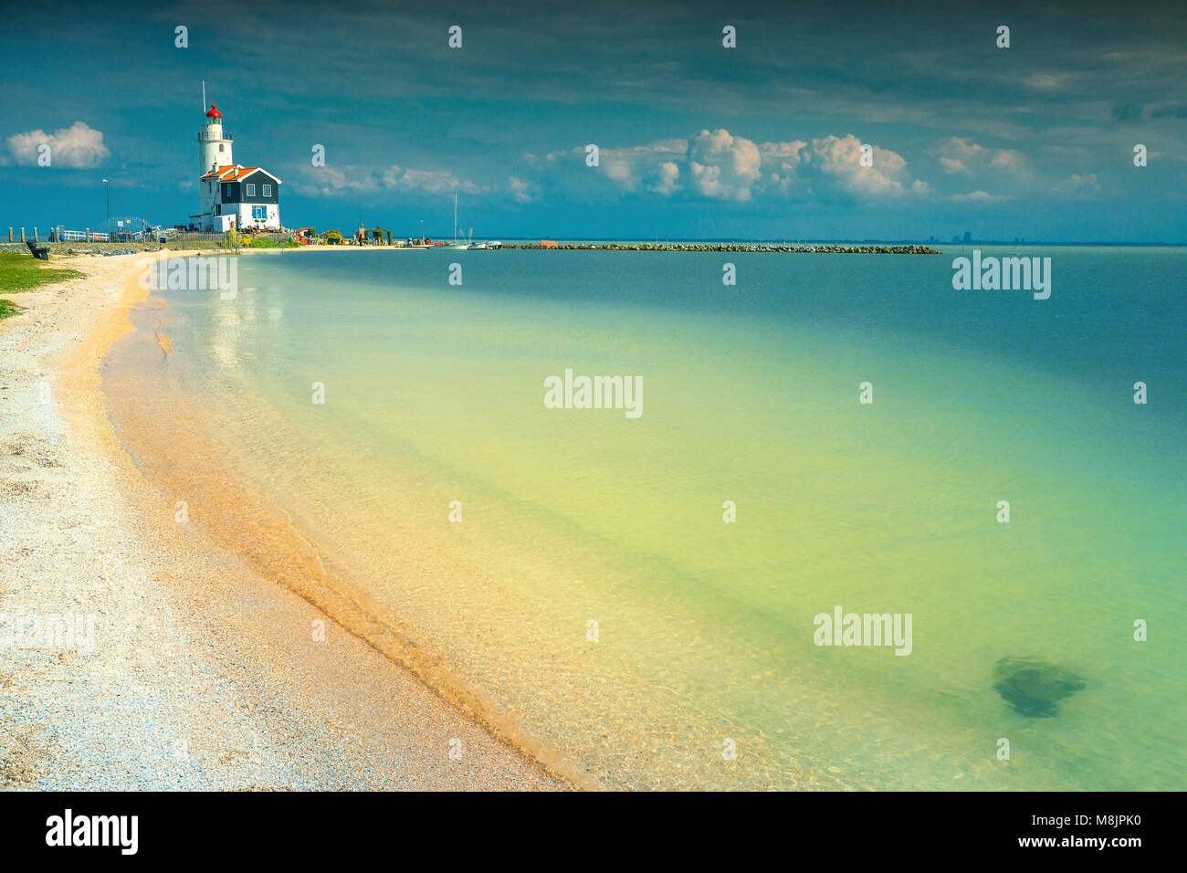 Majestic lighthouse on the island of Marken and stunning beach with ...