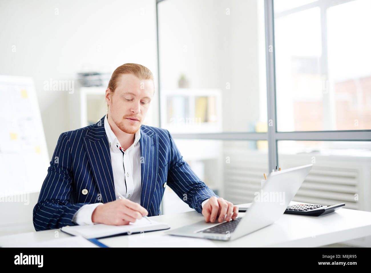 Young serious manager busy with his work Stock Photo - Alamy