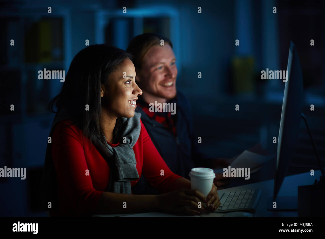 Businessman and businesswoman working on computer till night Stock ...