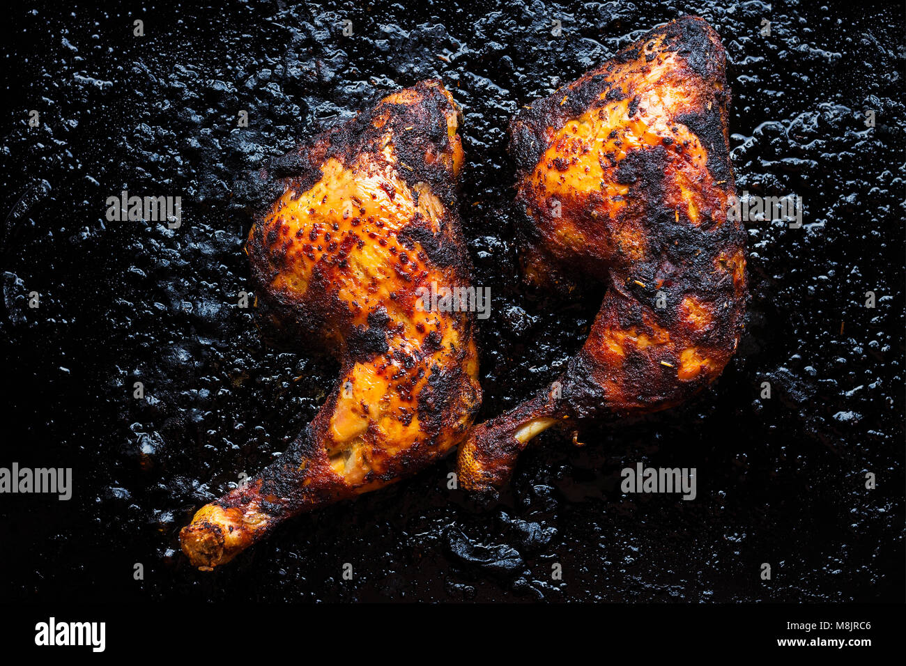 Charbroiled chicken legs and thighs, crispy and golden with charred ...