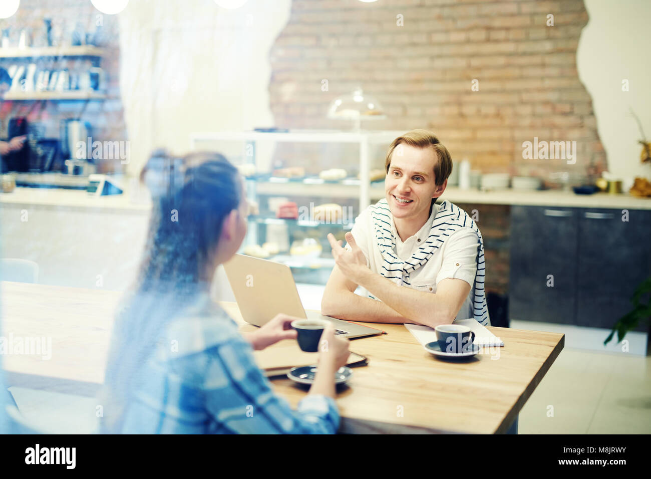 Smiling man having an interview with woman at coffee shop Stock Photo ...