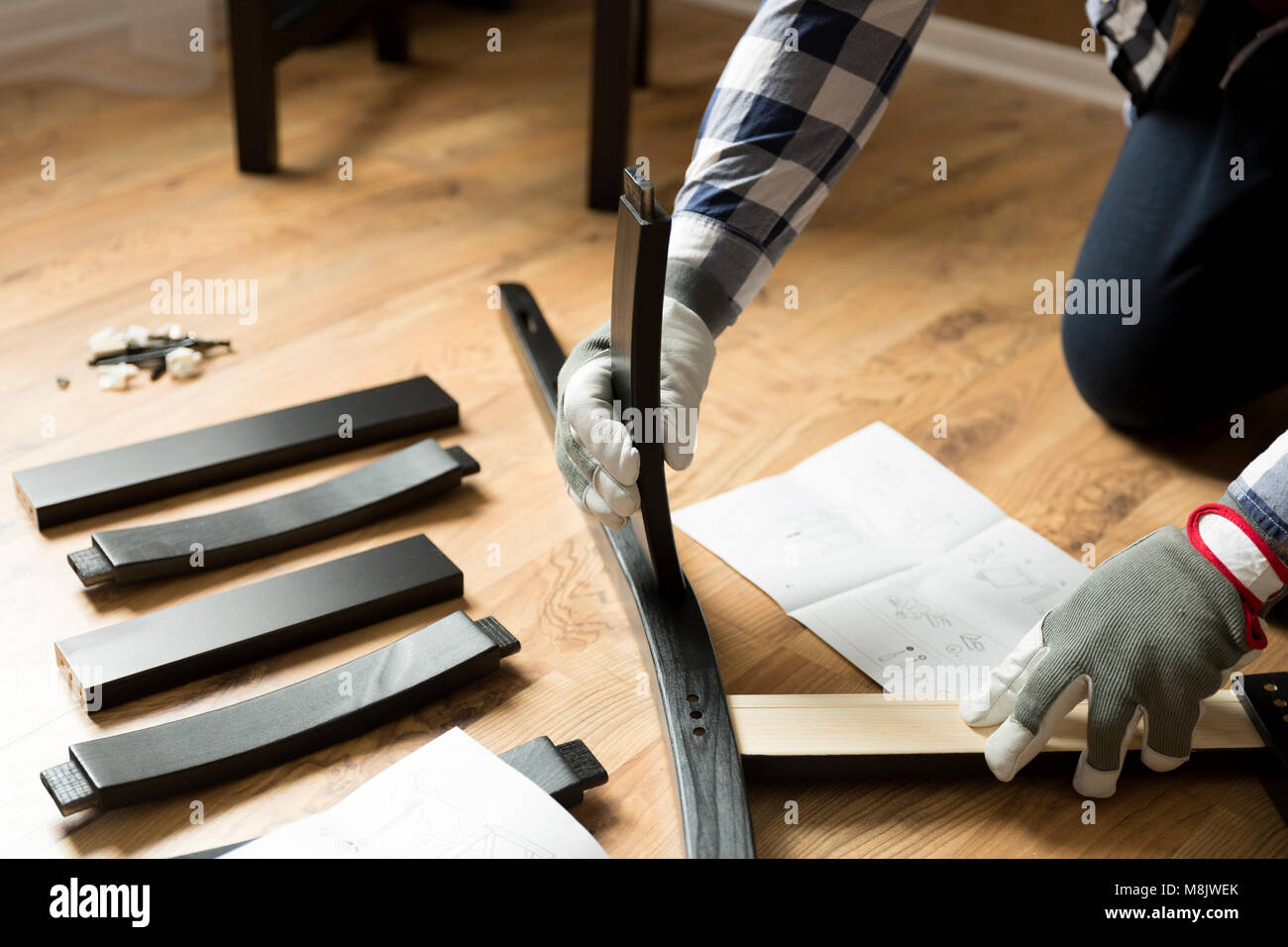 Assembly of wooden furniture, a woman putting together the wooden parts ...
