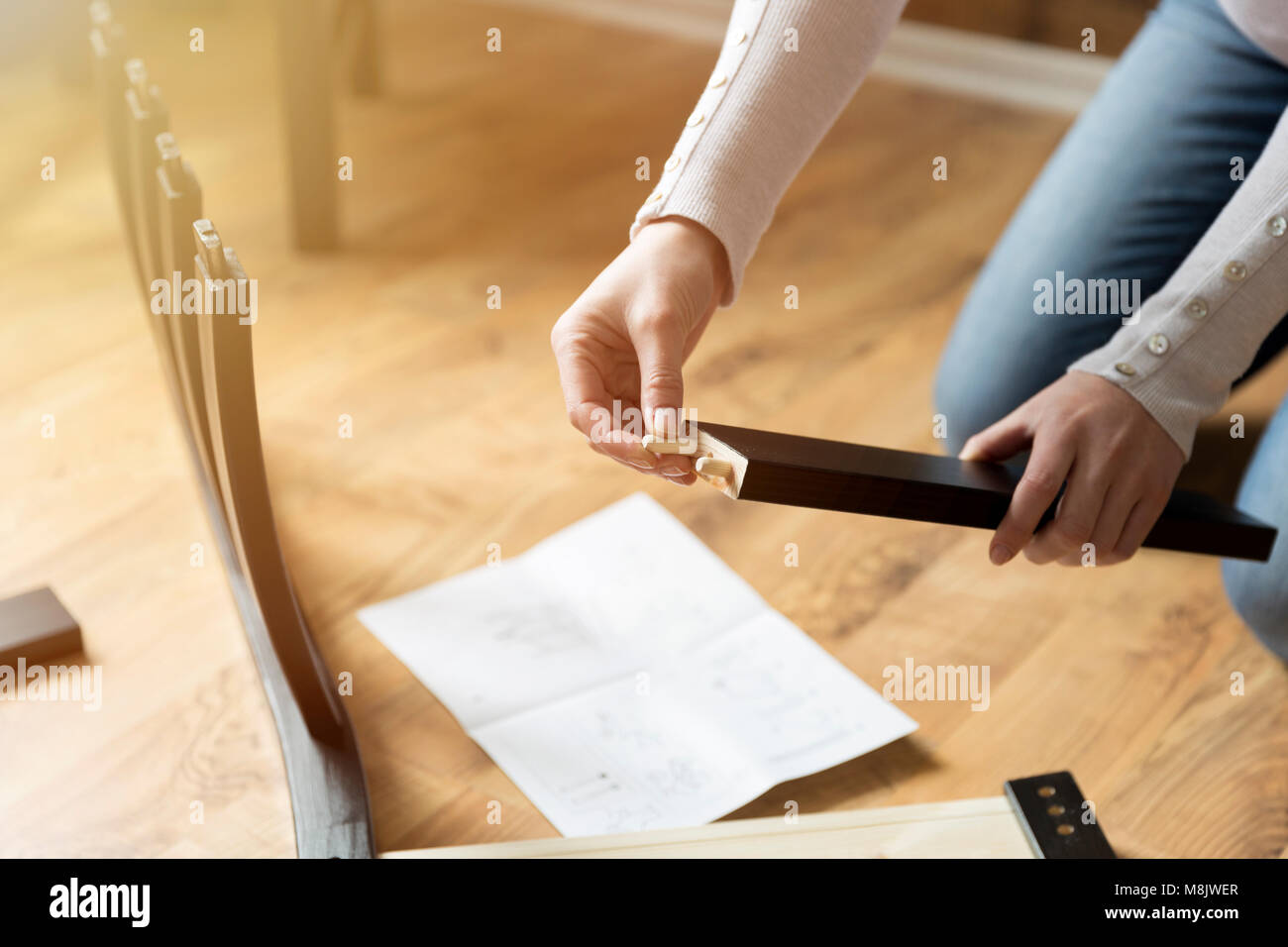 Assembly of wooden furniture, a woman putting together the wooden parts ...