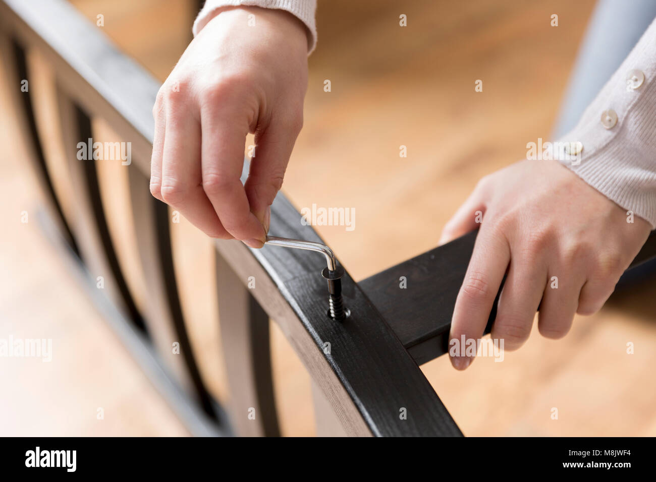 Assembly of wooden furniture, a woman putting together the wooden parts ...