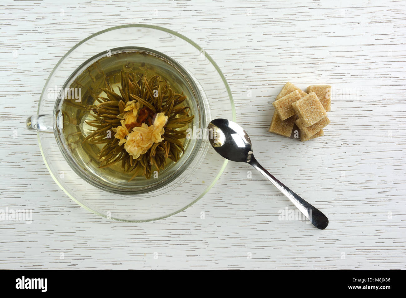 Cup of flowering tea with sugar cubes and spoon Stock Photo - Alamy