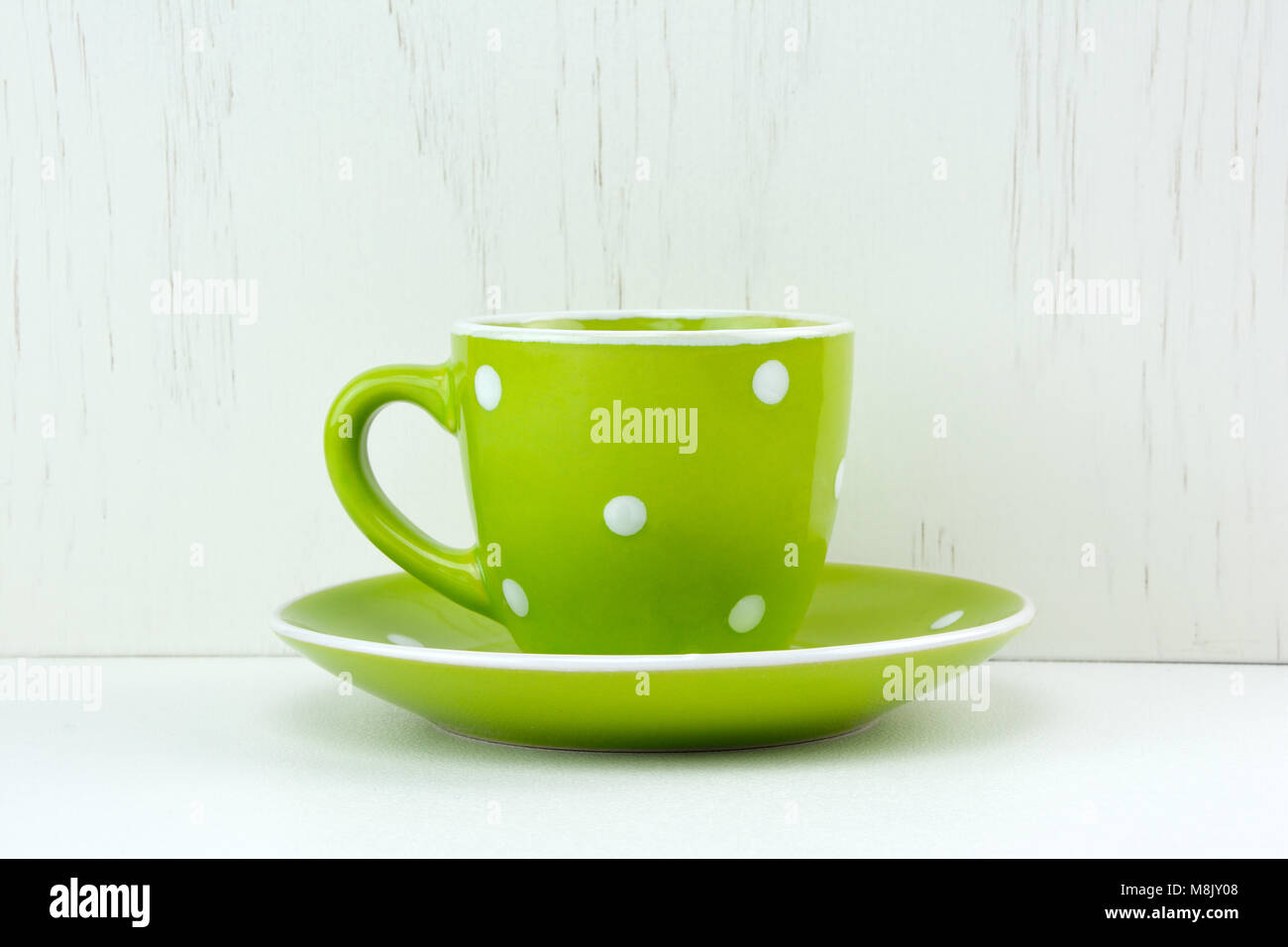 Green spotty mug on white background Stock Photo - Alamy