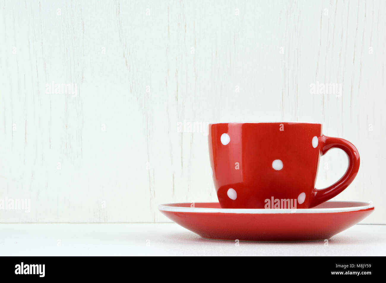 Red spotty mug on white background Stock Photo - Alamy
