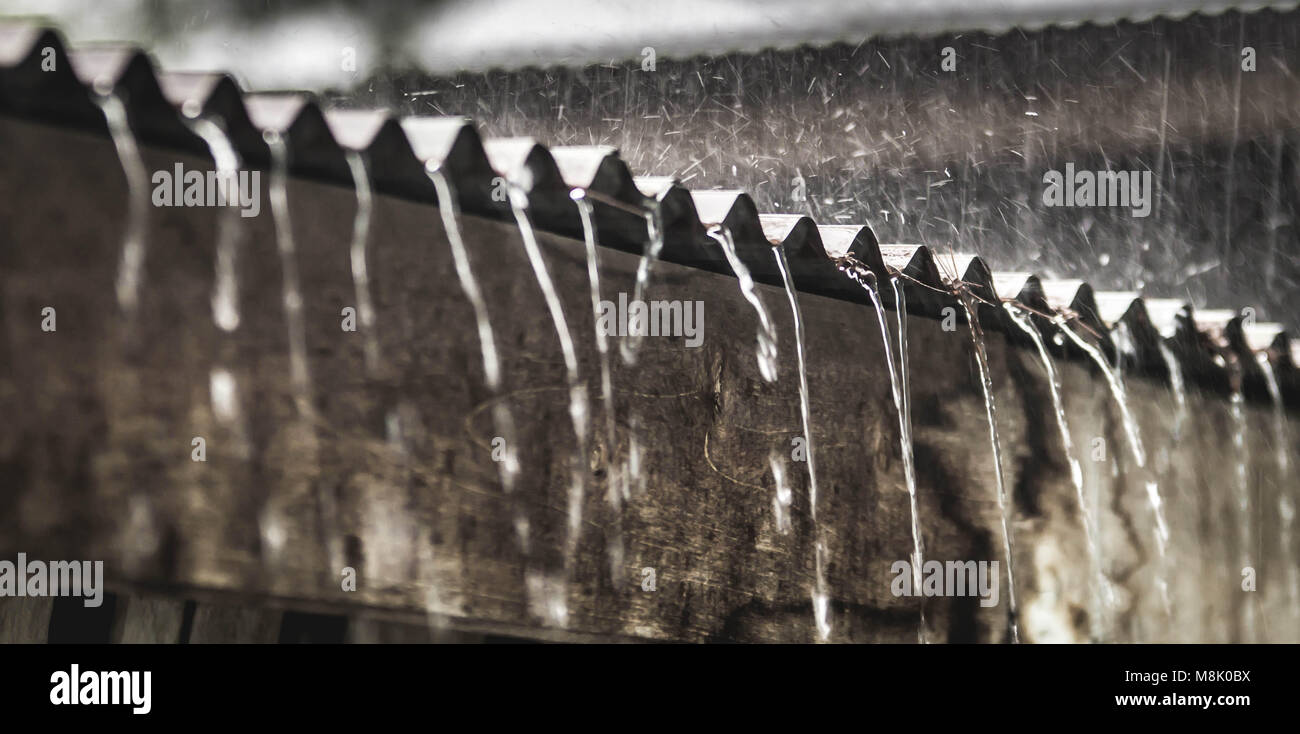 closeup of the rain falling from wavy metal roof sheet. Climate and ...