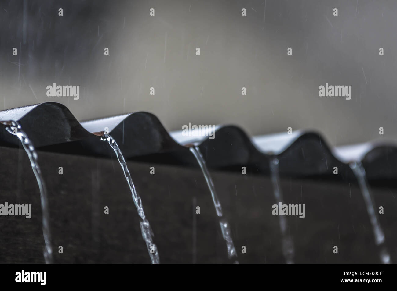 closeup of the rain falling from wavy metal roof sheet. Climate and ...