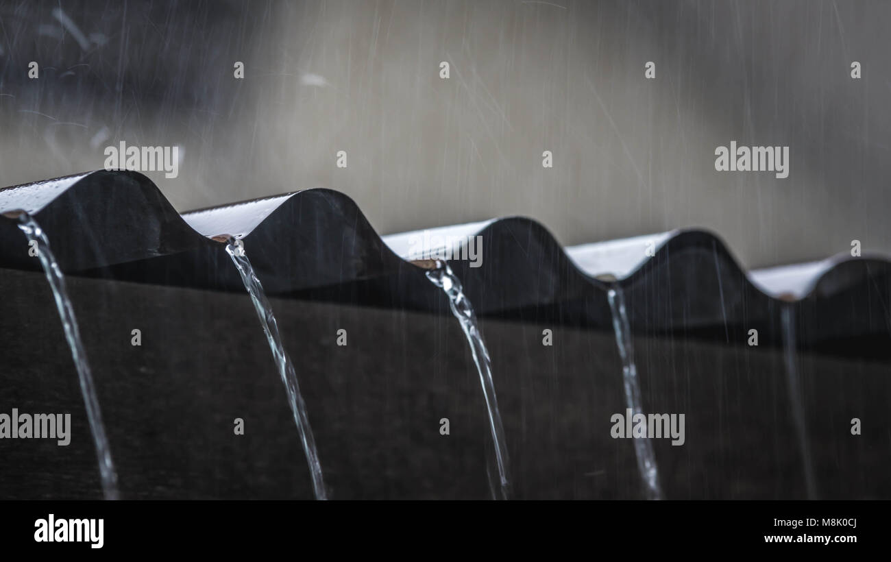 closeup of the rain falling from wavy metal roof sheet. Climate and ...
